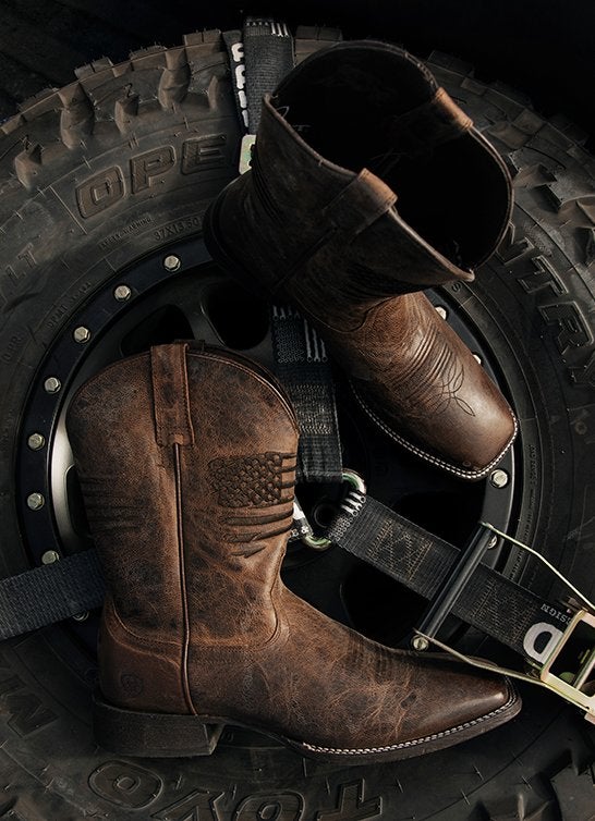Pair of boots laying on a tire